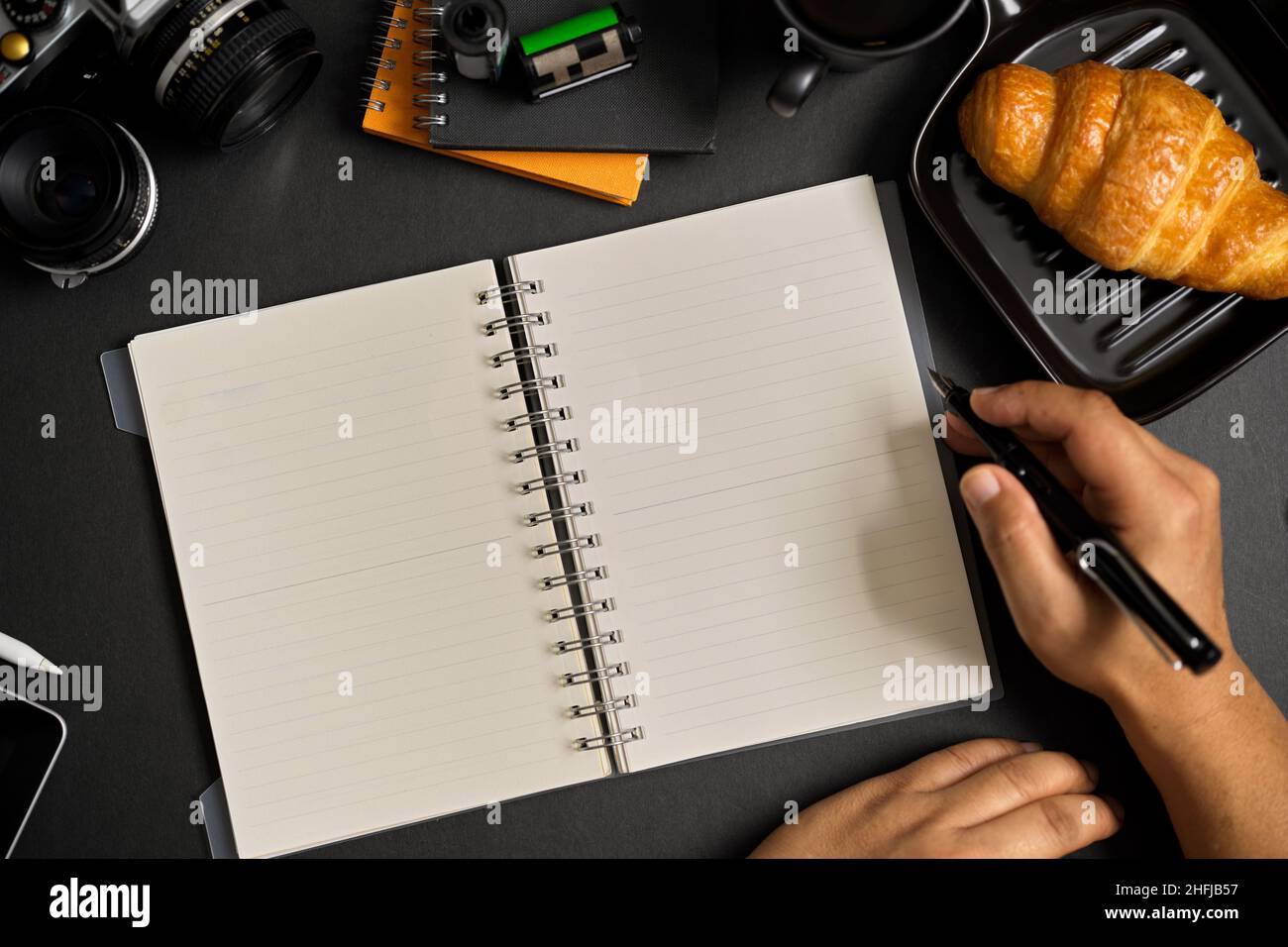 Top view, flat lay modern workspace on black background. A man taking ...