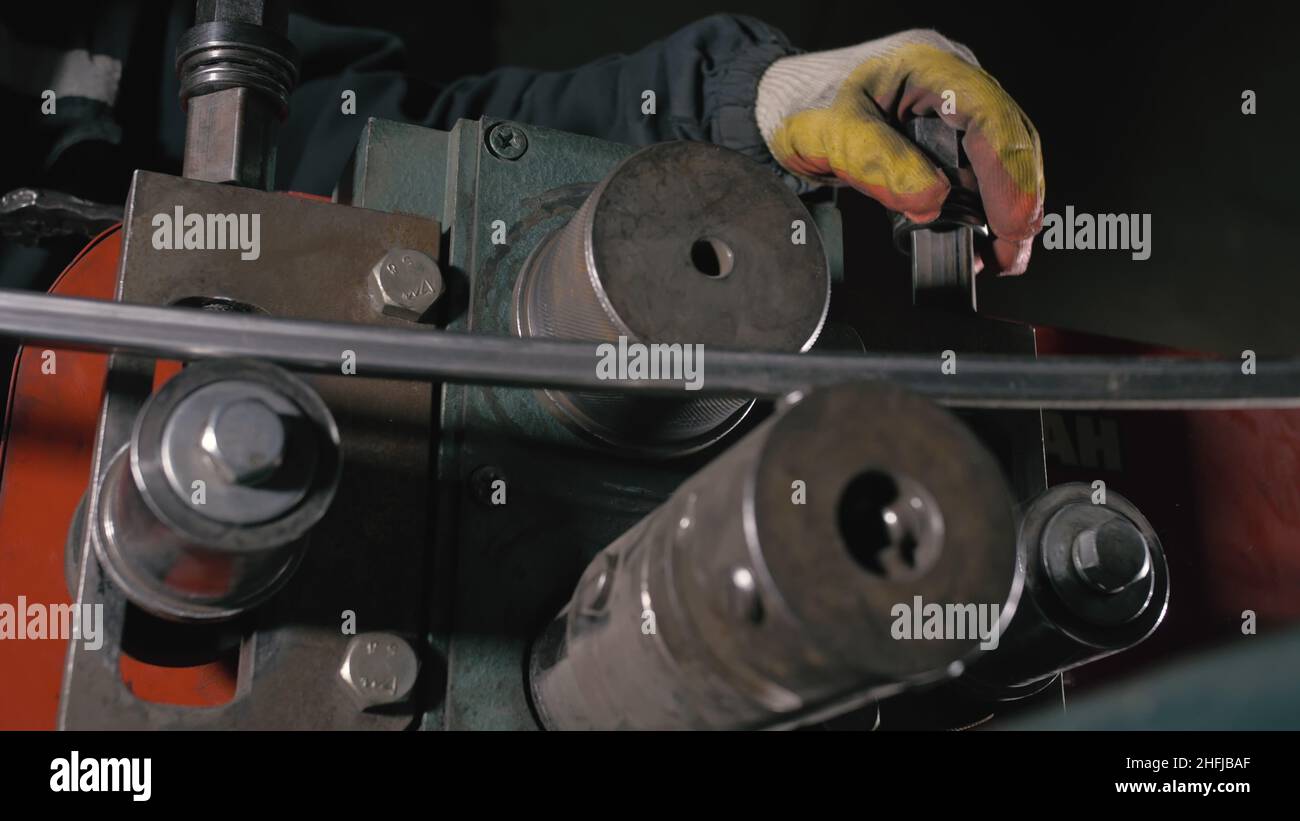 Forge workshop on table. Worker bends the metal rod on the wrought iron ...