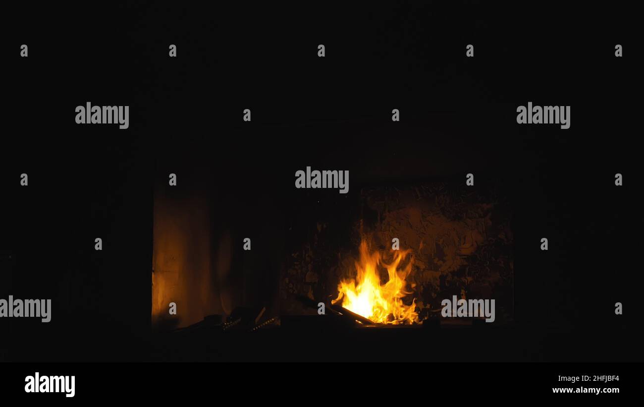 Forge fire in furnace. Blacksmith tempers a steel product in a stove ...