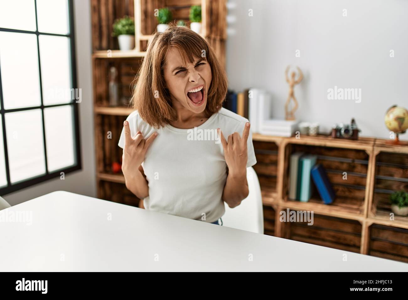 Young caucasian girl wearing casual clothes sitting on the table at ...