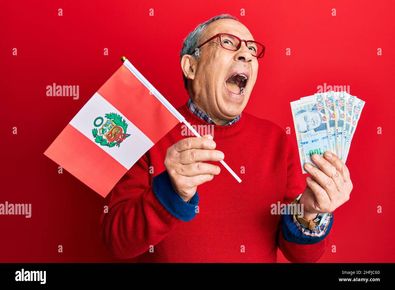 Handsome senior man with grey hair holding peru flag and peruvian sol ...