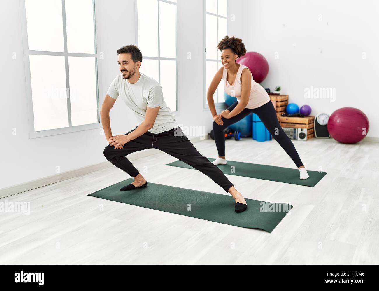 Young african american woman and hispanic man exercising at pilates ...