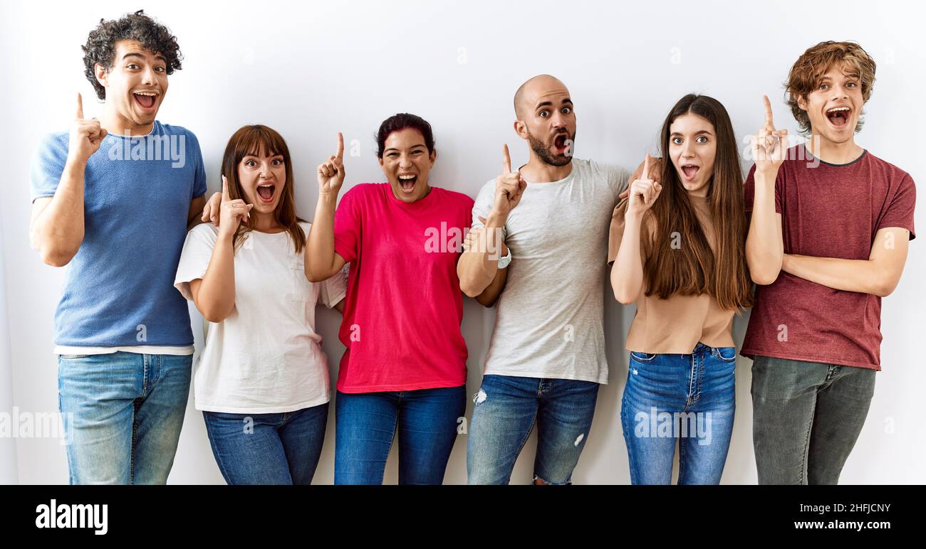 Group of young friends standing together over isolated background ...