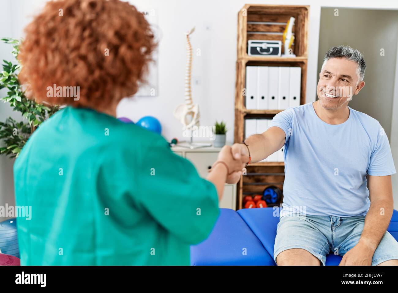 Middle age man and woman wearing physiotherapy uniform having rehab ...