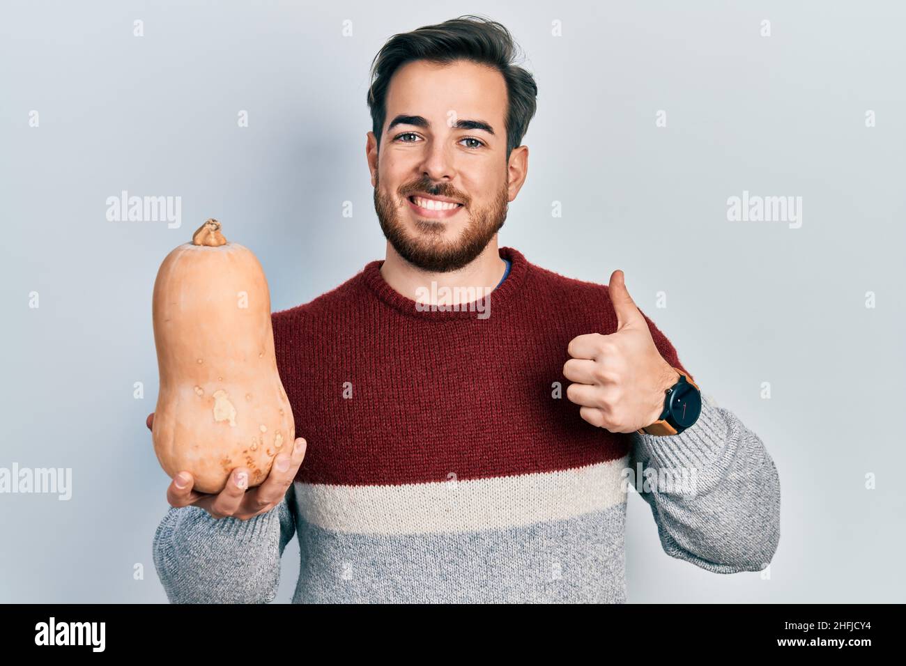 Handsome caucasian man with beard holding healthy fresh pumpkin smiling ...