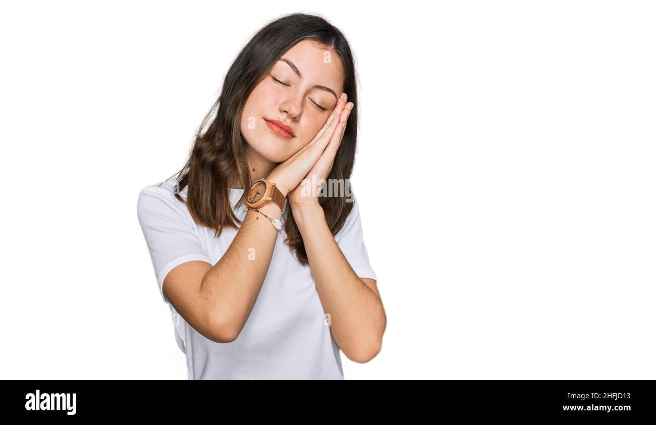 Young beautiful woman wearing casual white t shirt sleeping tired ...