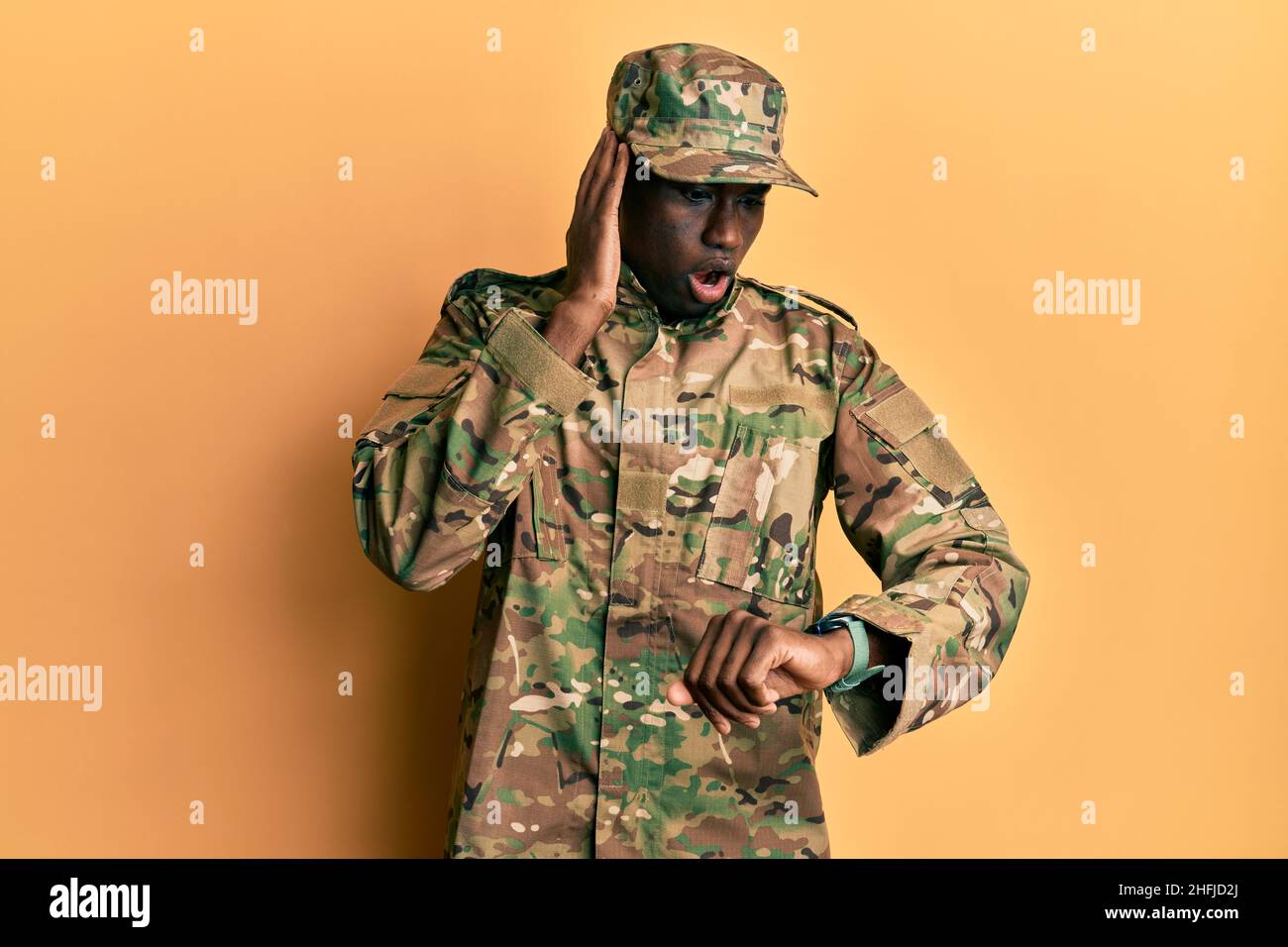 Young african american man wearing army uniform looking at the watch ...