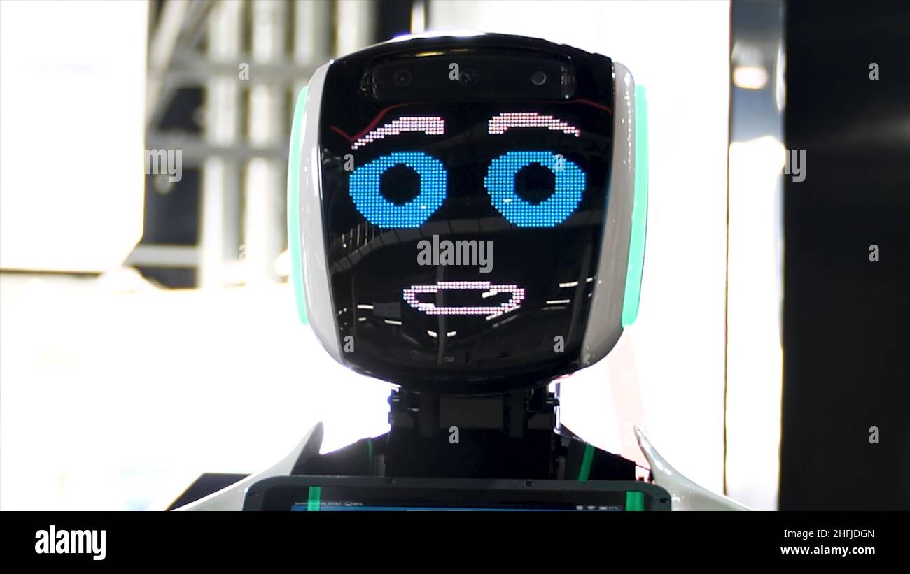 Funny robot with big blue eyes smiling and talking. Close up of robot ...
