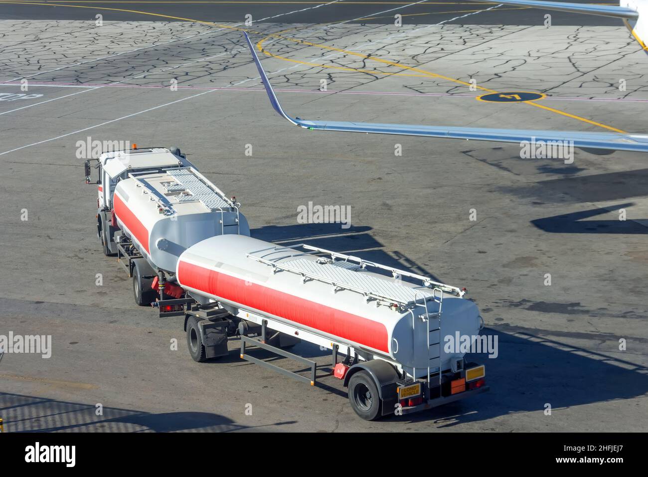 A truck with jet fuel tanks and a trailer on the airfield delivers fuel ...