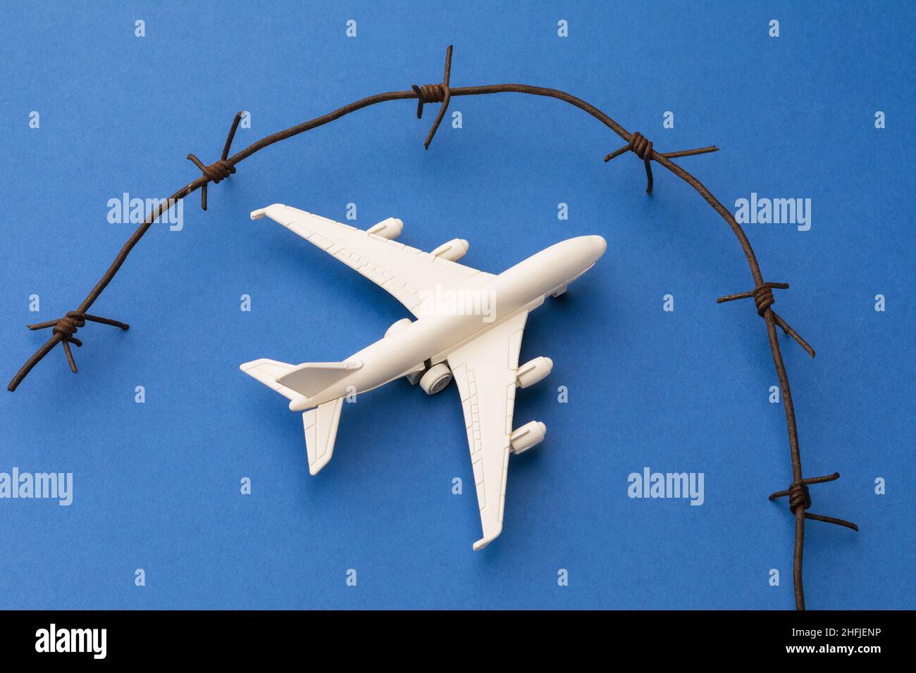 Airplane and barbed wire on a blue background, closed airspace concept ...