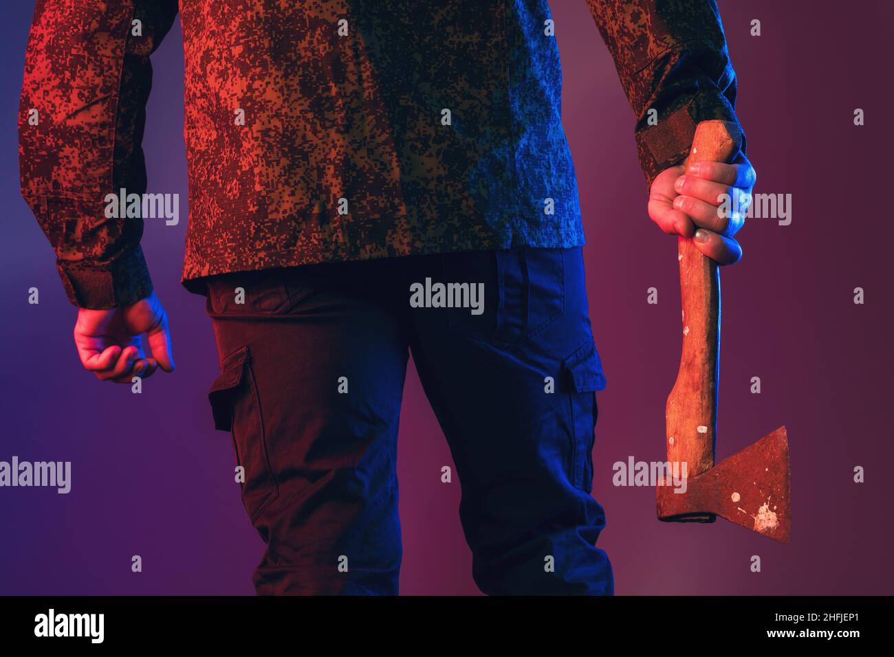 A man with an ax in his hands, illuminated by blue and red light Stock ...