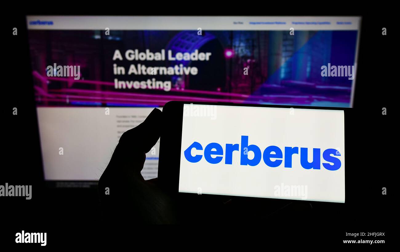 Person holding mobile phone with logo of American company Cerberus ...