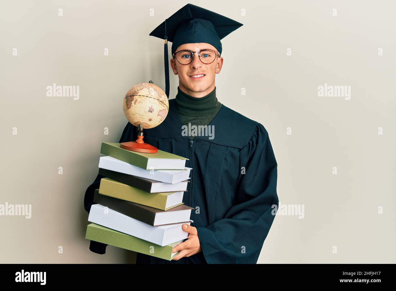 Young caucasian man graduated on geography smiling with a happy and ...
