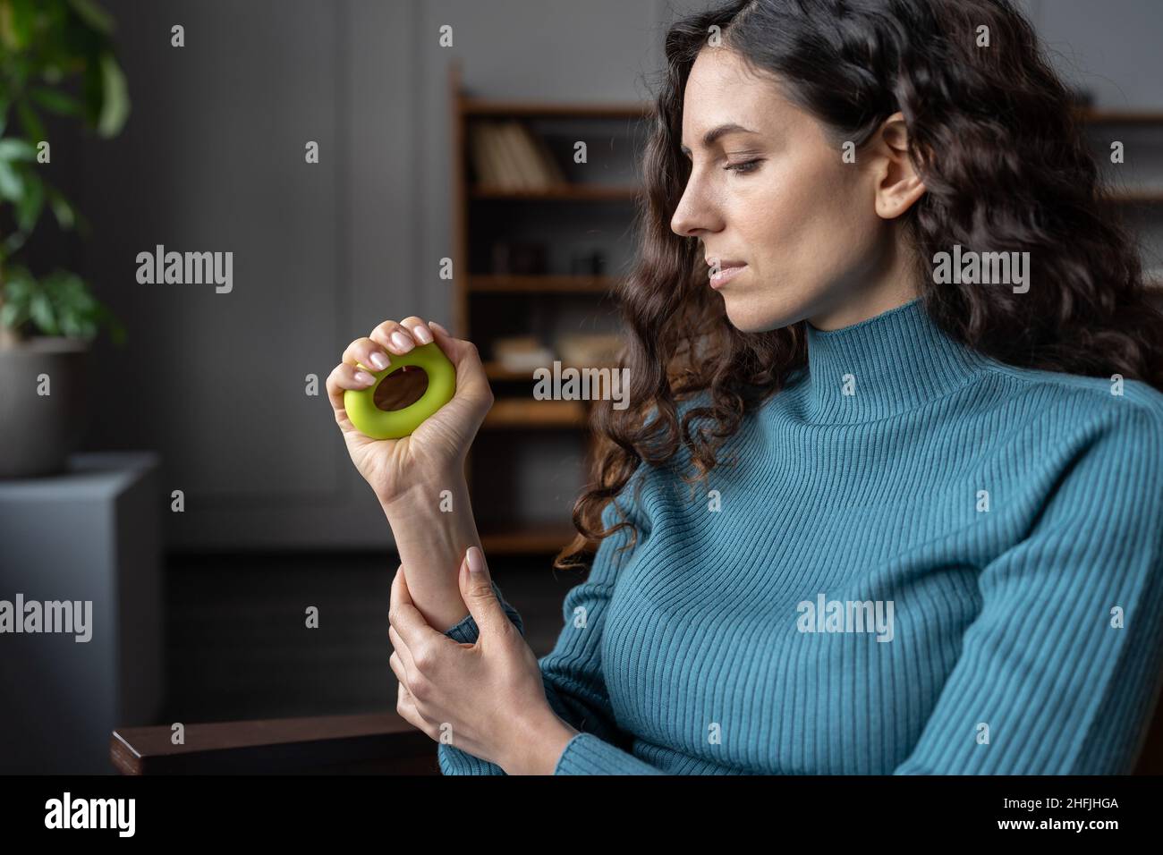 Female office worker exercising with hand grip at workplace for ...