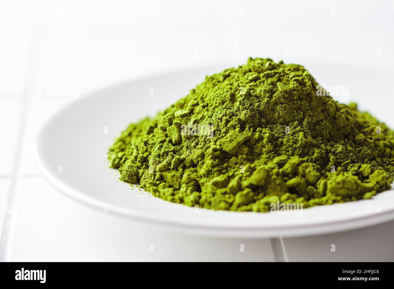 Matcha green tea powder on a white plate, close-up. Traditional ...
