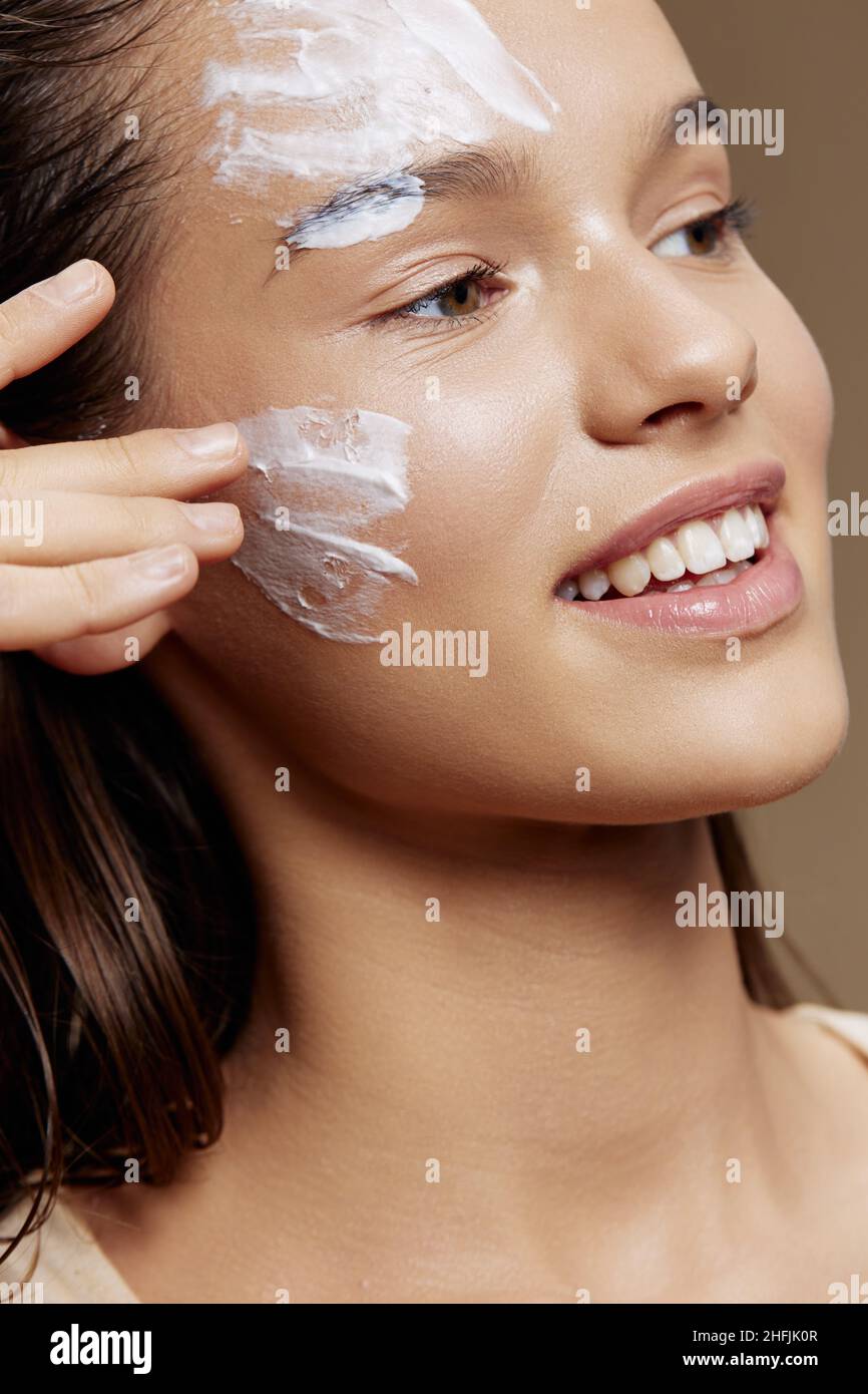 Smiling young woman face mask cream clean skin facial scrub close-up ...