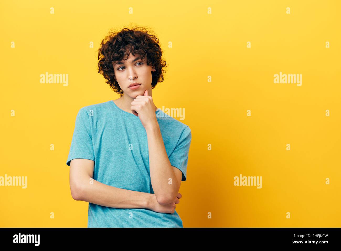 teenager guy blue t-shirts on a yellow background portrait Stock Photo ...