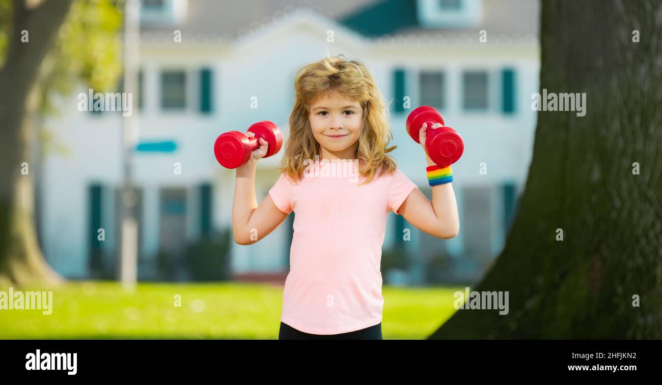 Child boy working out with dumbbells on park background. Kids sport ...