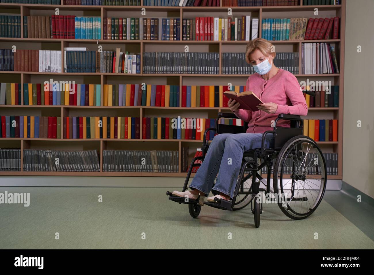 Attentive female person reading book in waiting room Stock Photo - Alamy