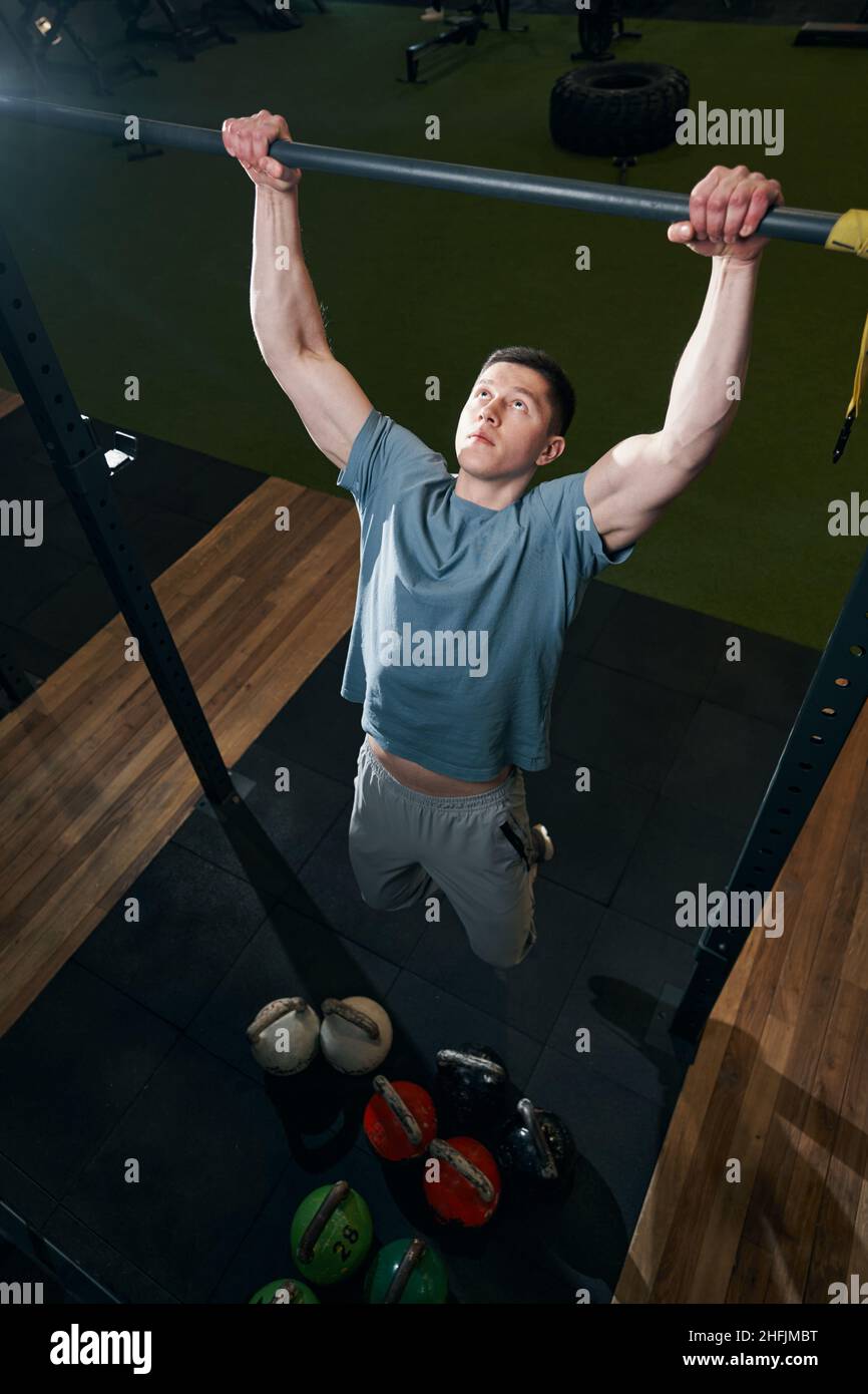 Strong young man doing dead hang exercise Stock Photo - Alamy