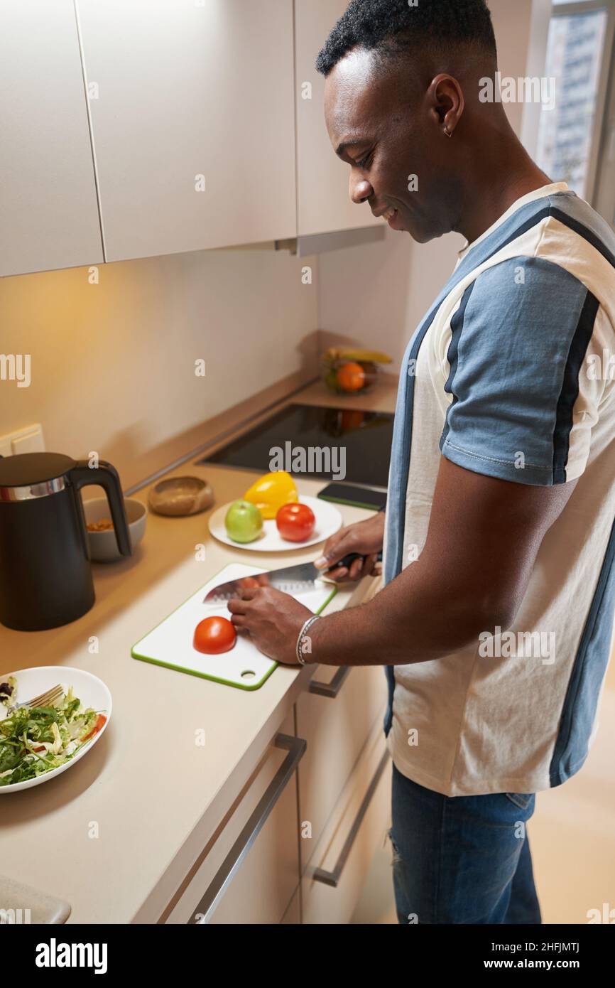 Mixed-race man cooking meal in the kitchen Stock Photo - Alamy