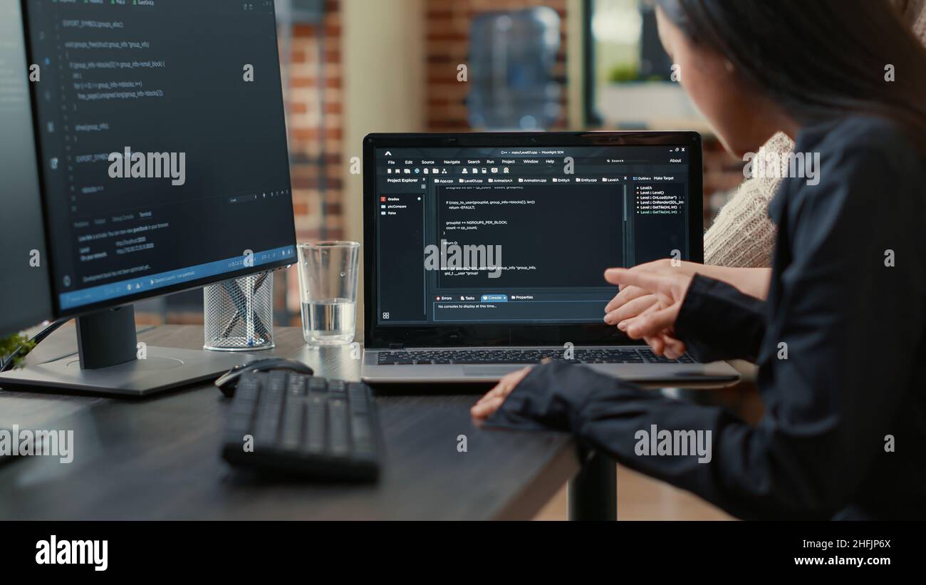Team Of Programmers Talking About Algorithm Running On Laptop Screen Pointing At Source Code