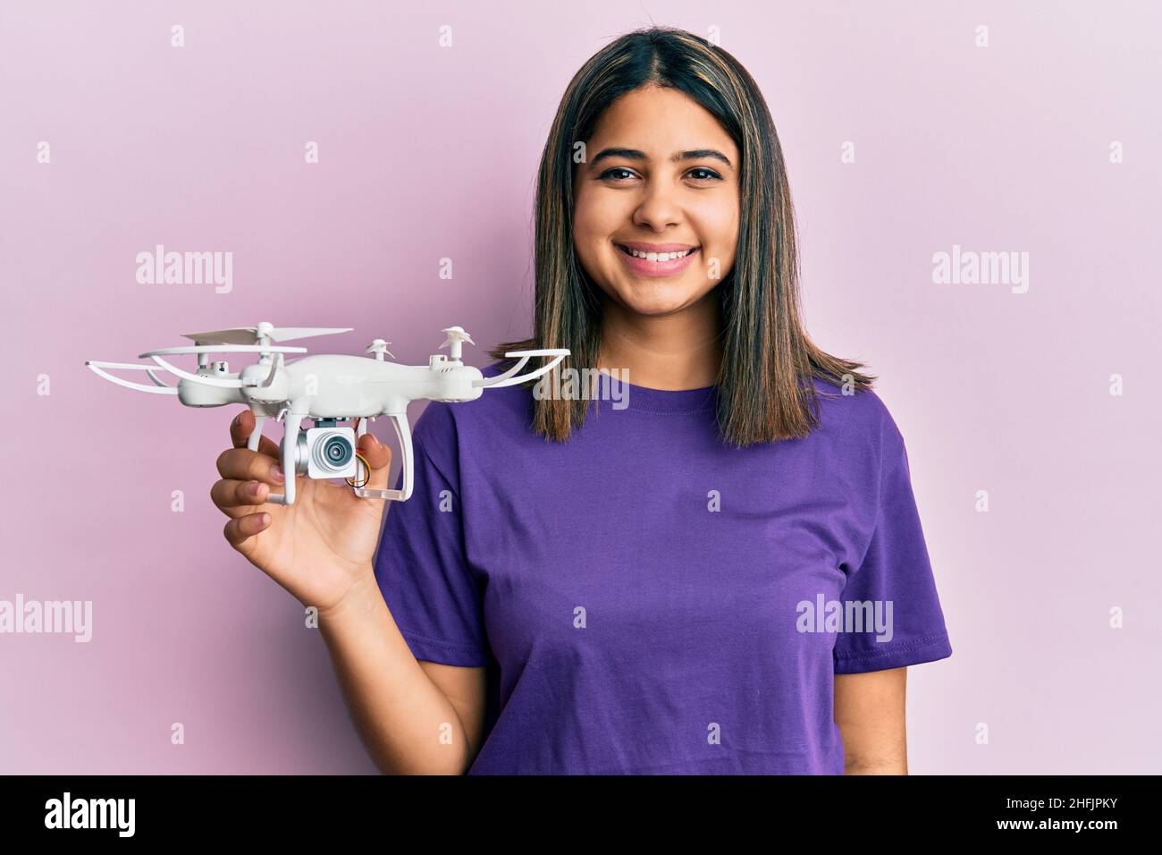 Young latin woman using drone looking positive and happy standing and ...