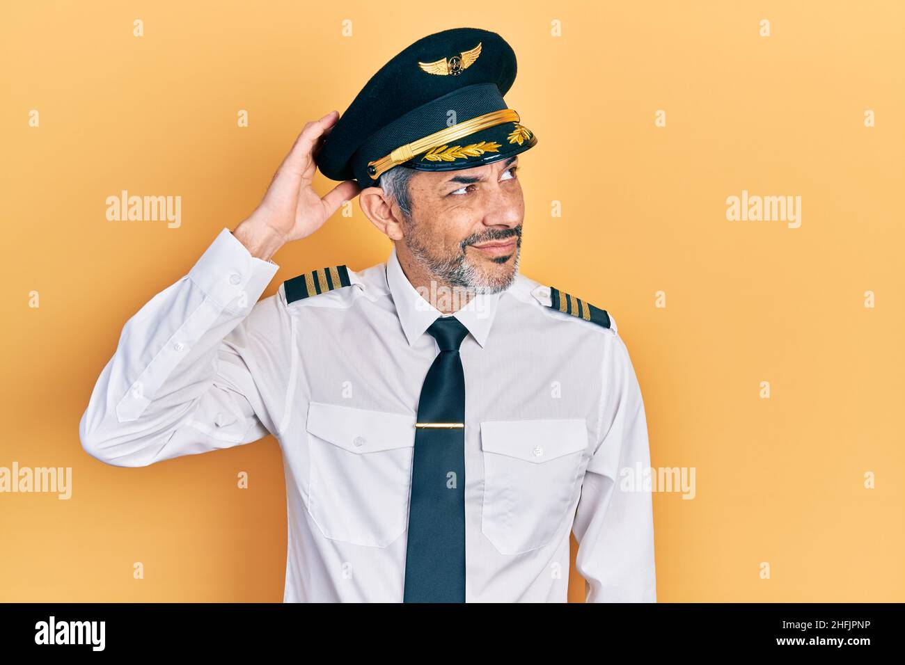 Handsome middle age man with grey hair wearing airplane pilot uniform ...