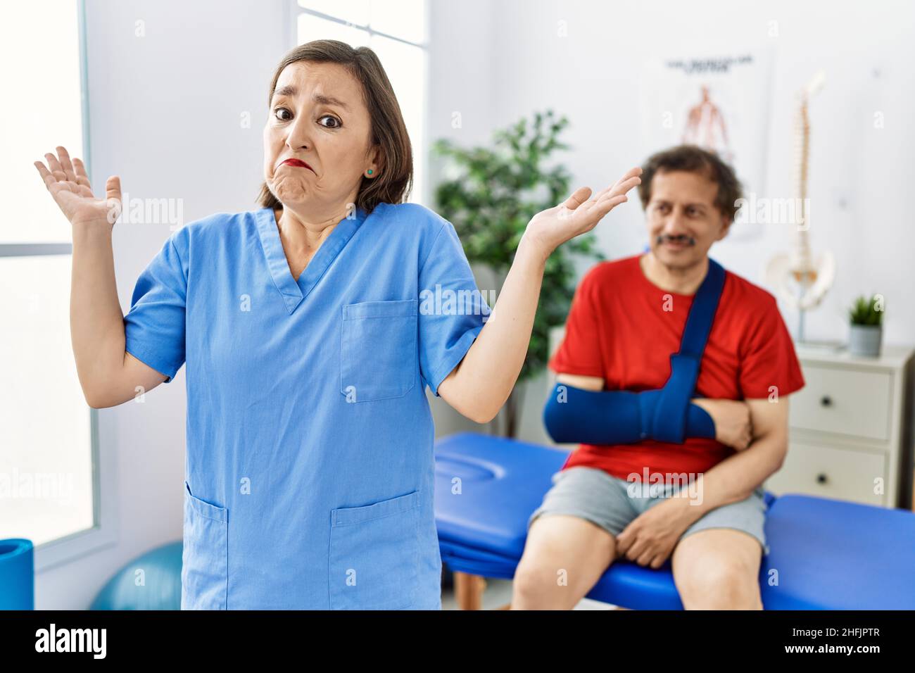 Middle age doctor woman with patient with arm injury at rehabilitation ...