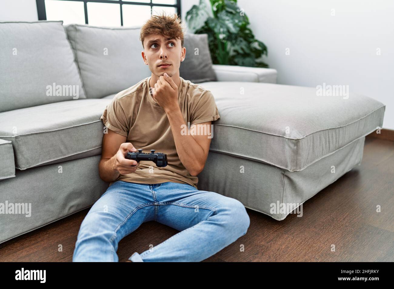Young caucasian man playing video game holding controller at home ...