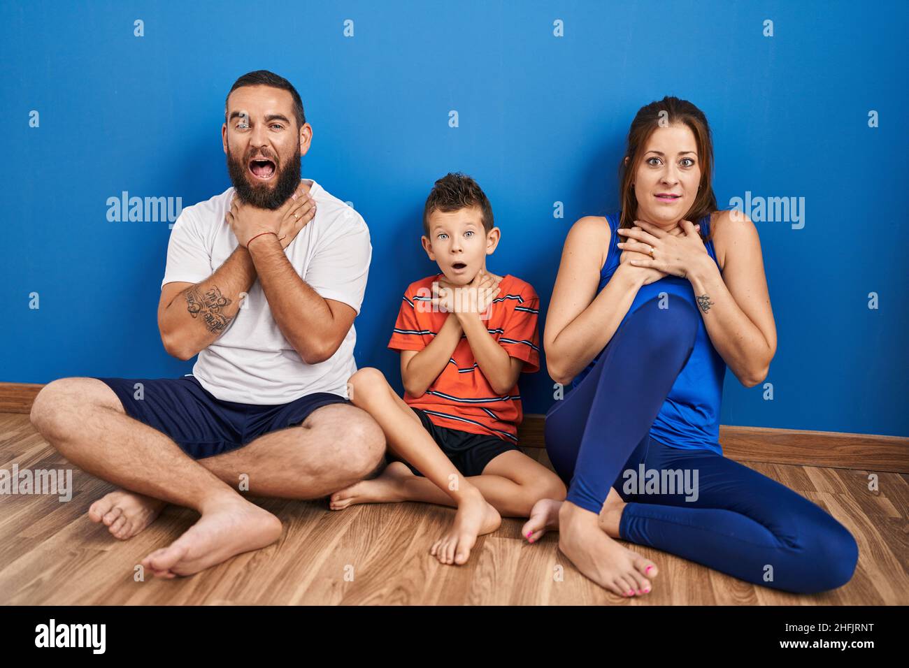 Family of three sitting on the floor at home shouting and suffocate ...