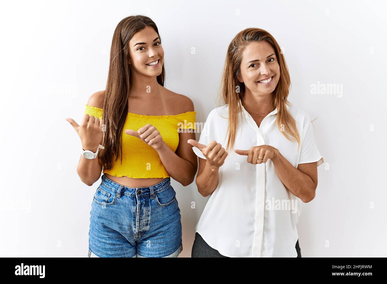 Mother and daughter together standing together over isolated background ...