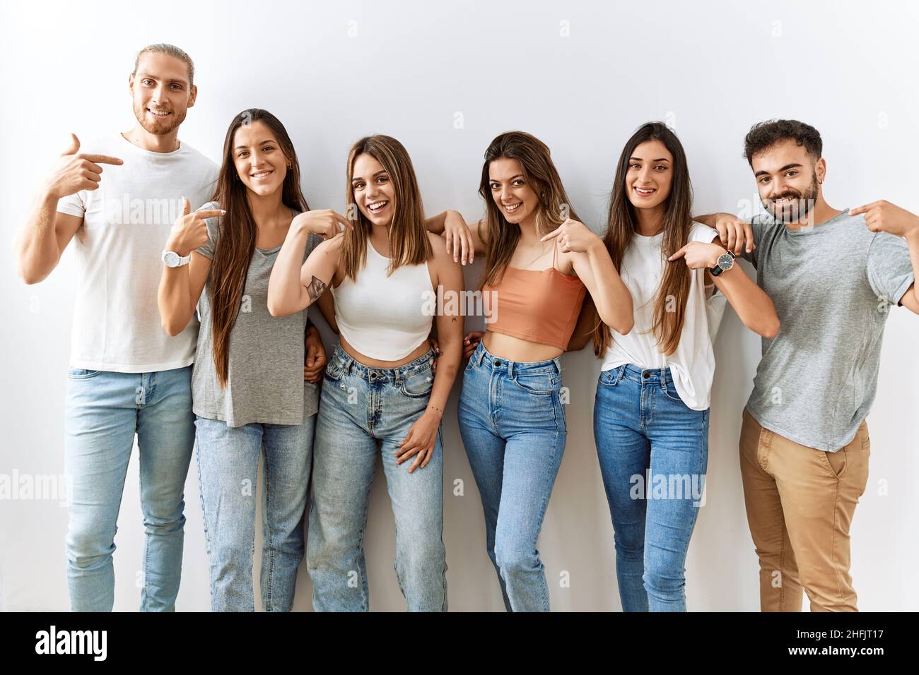 Group of young friends standing together over isolated background ...