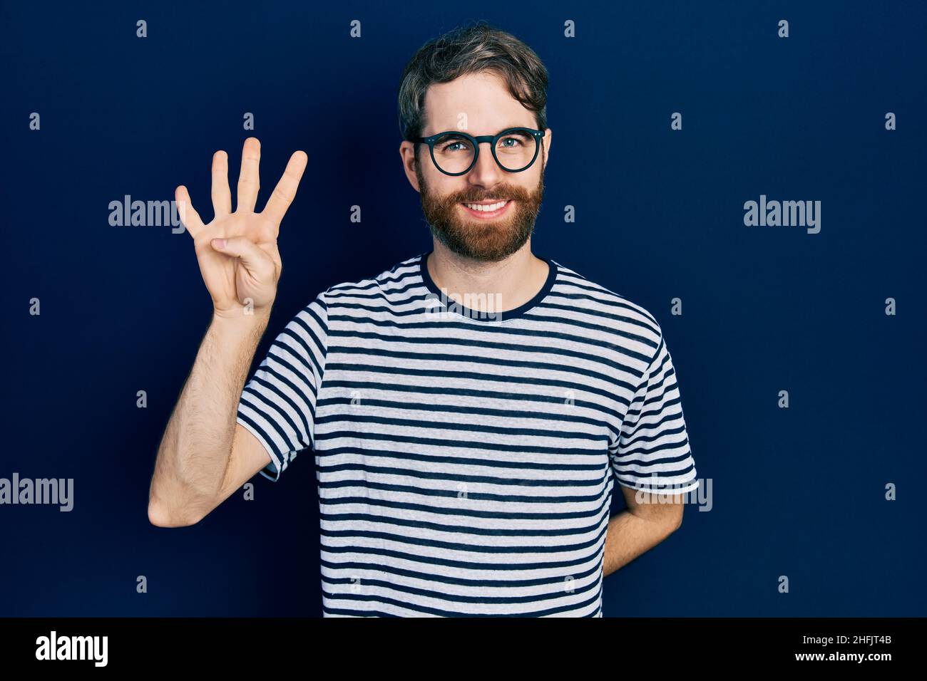 Caucasian man with beard wearing striped t shirt and glasses showing ...
