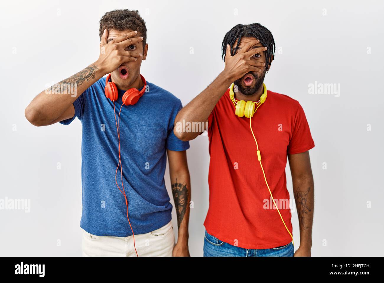 Young hispanic brothers standing over isolated background wearing ...