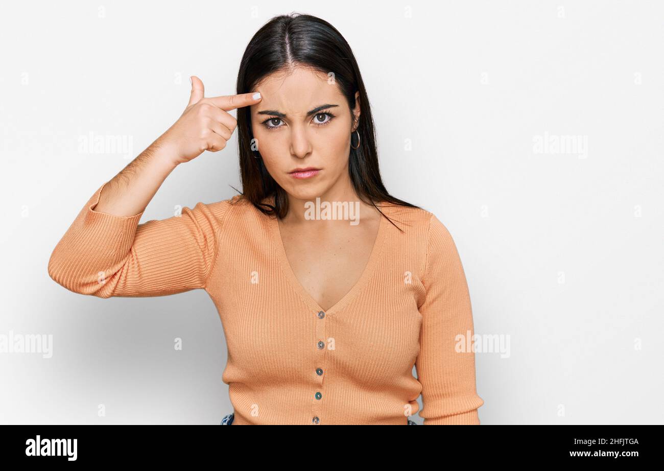 Young hispanic woman wearing casual clothes pointing unhappy to pimple ...