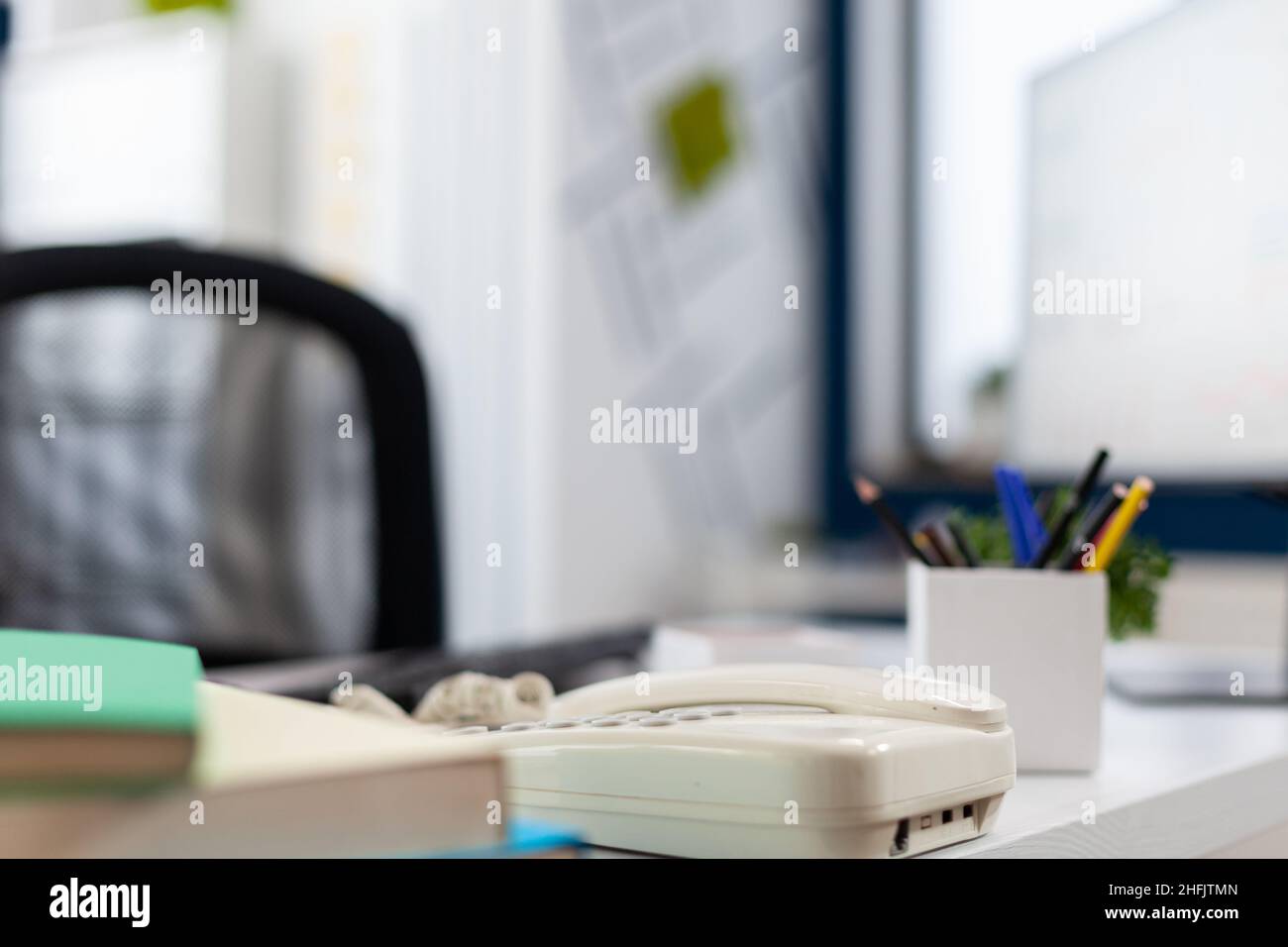 Closeup of phone on desk in empty business office. Startup workspace ...