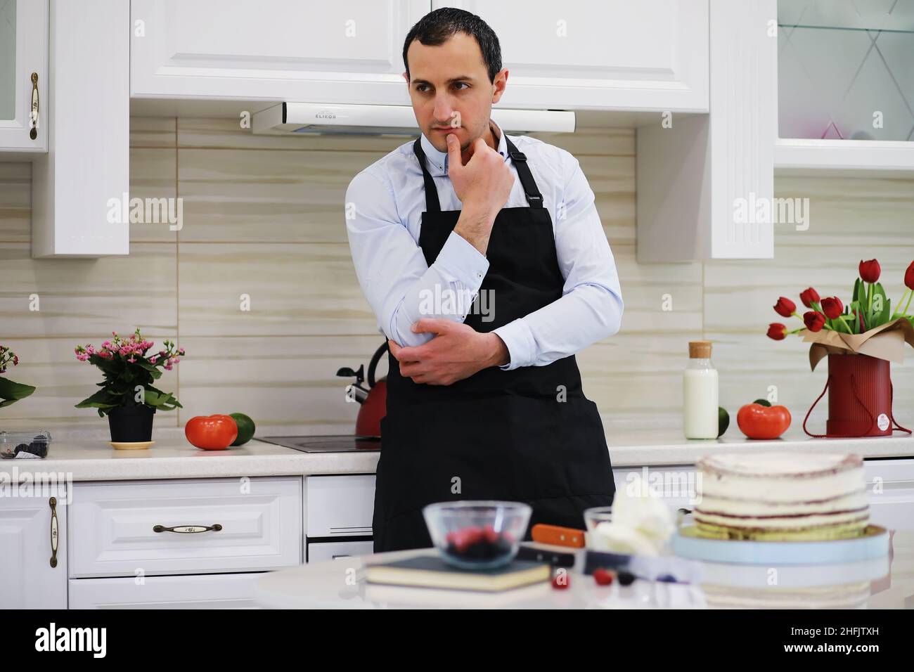 Master pastry chef in front of a desk. Cooking desserts at home. The ...