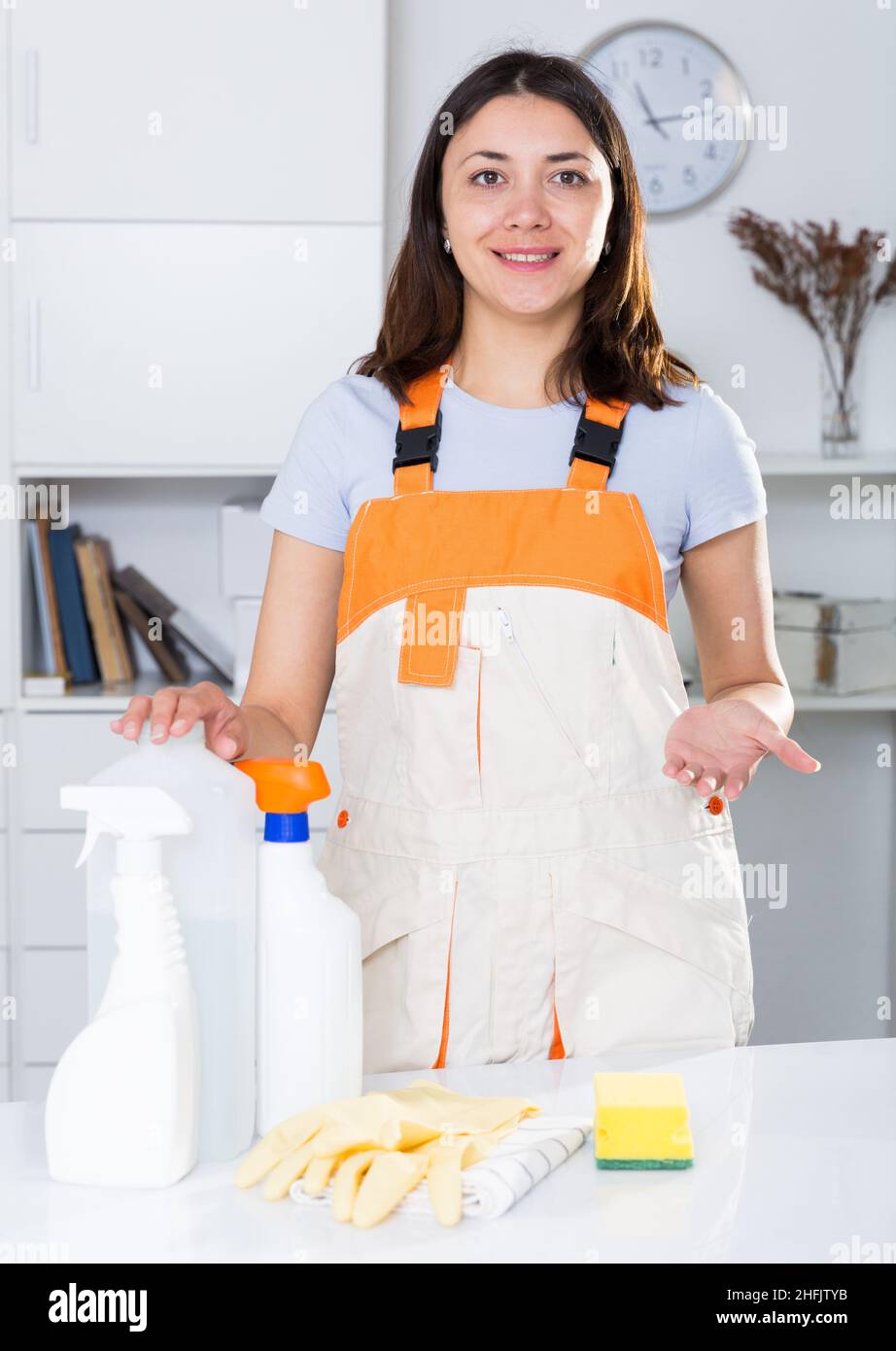 Young woman in uniform standing before cleaning in office Stock Photo ...