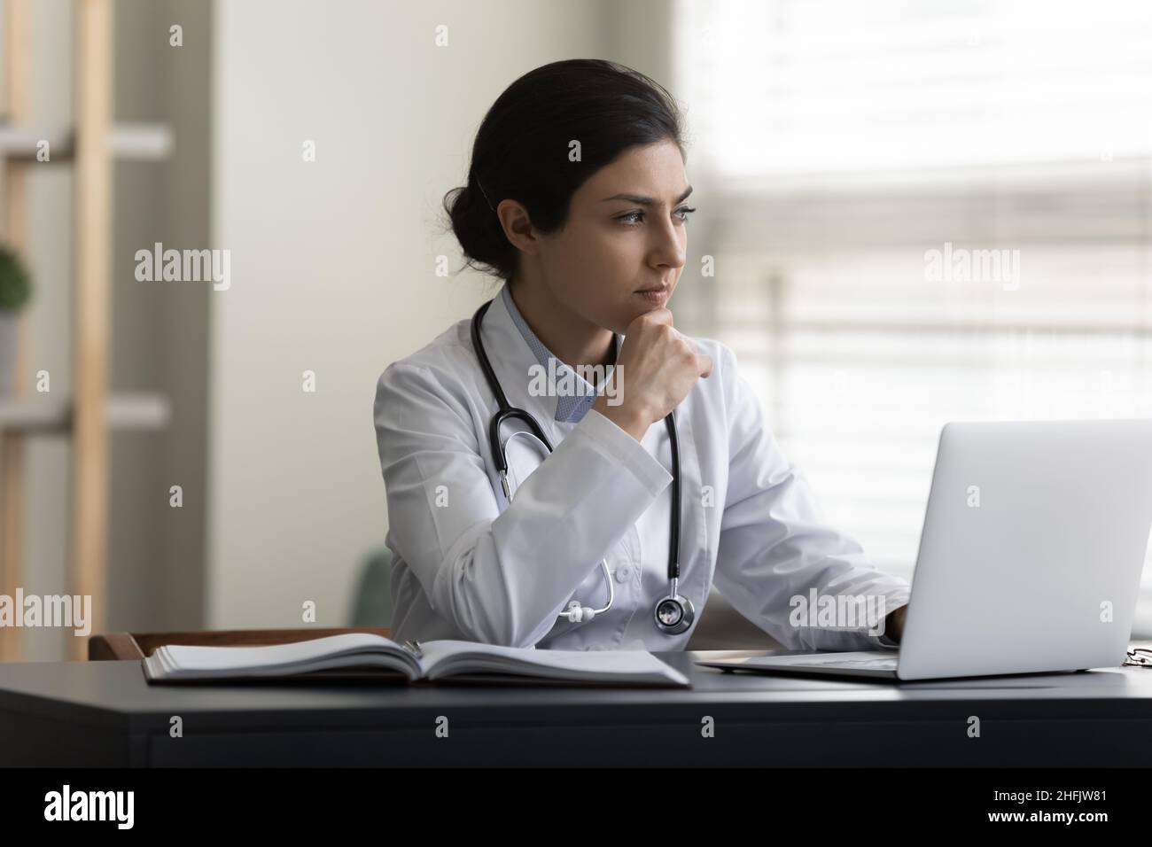 Stressed young Indian doctor considering illness treatment Stock Photo ...