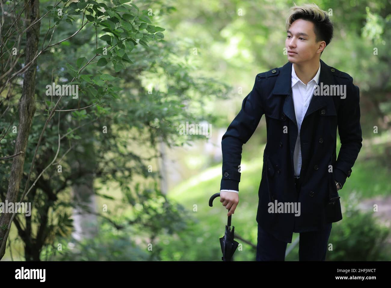 Spring Park in rainy weather and a young man with an umbrella Stock ...