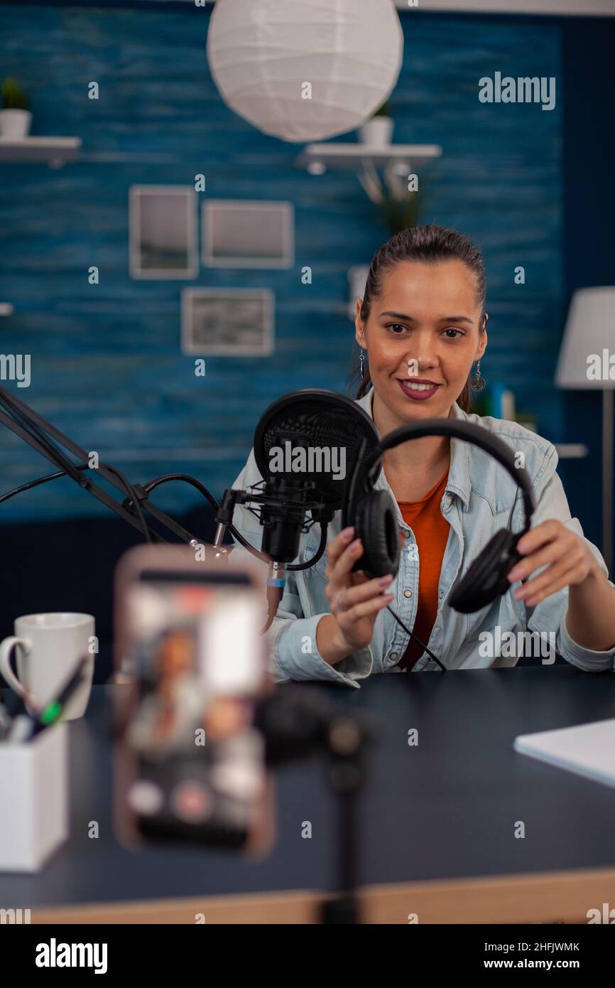 Smiling influencer recording podcast with headphones and microphone ...