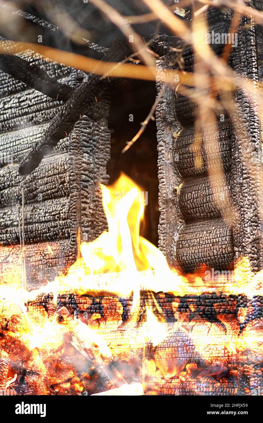 Wooden house after the fire. Coals on the logs. The ashes of the house ...