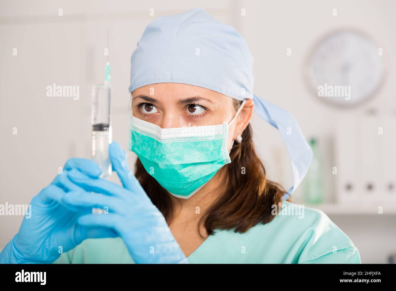 Female nurse in mask holding syringe for injection in hospital Stock ...