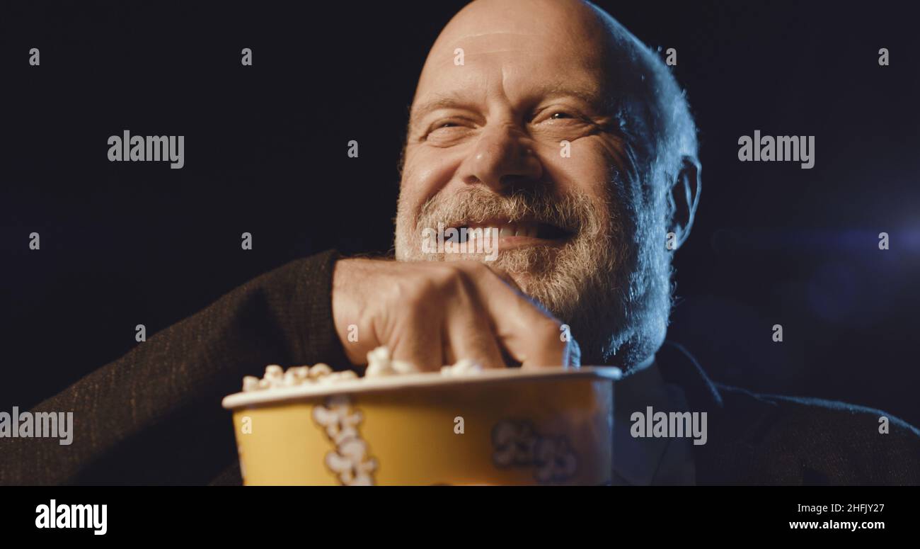 Man cinema laughing eating popcorn hi-res stock photography and images ...