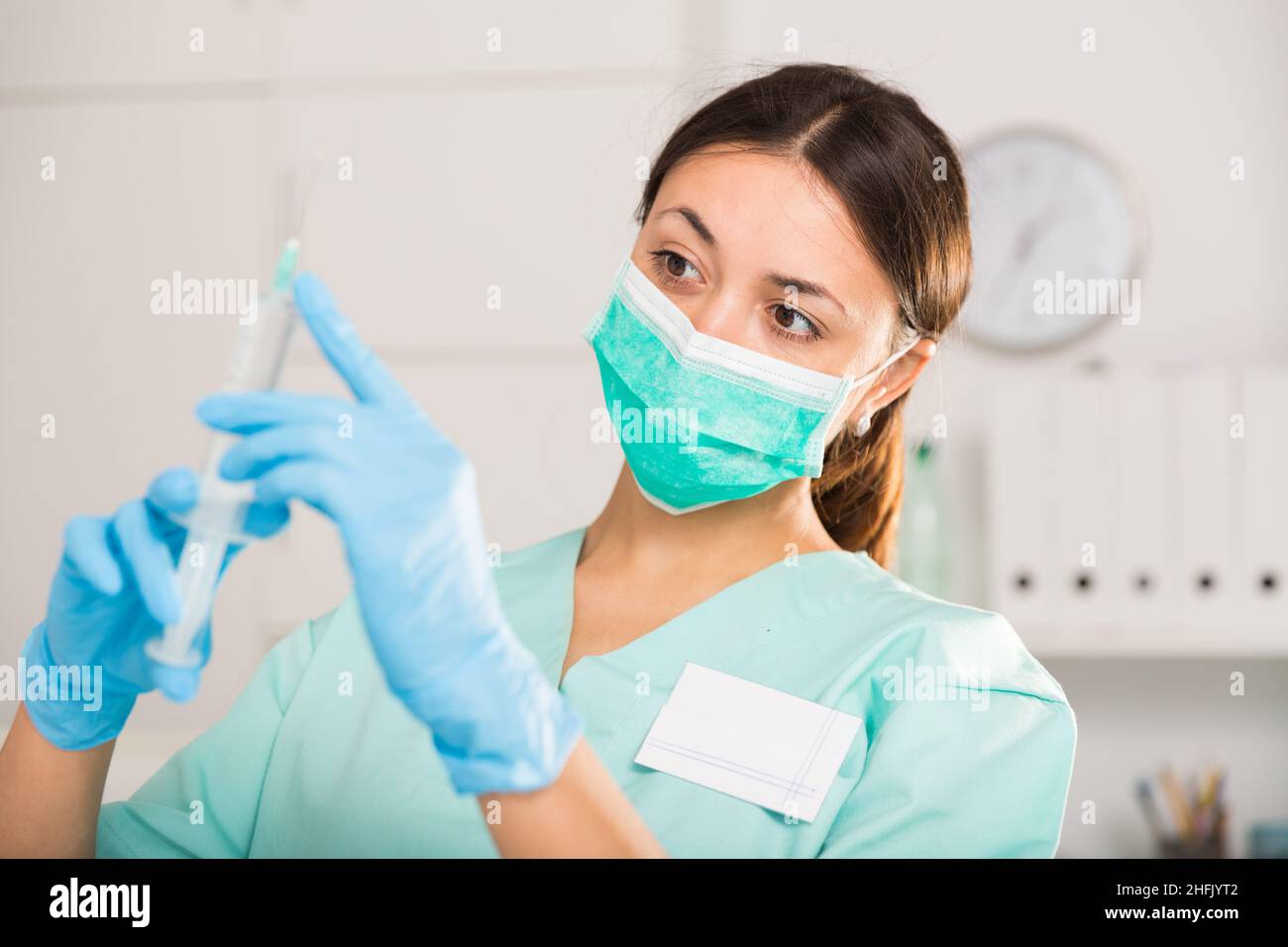 Female nurse in mask holding syringe for injection in hospital Stock ...