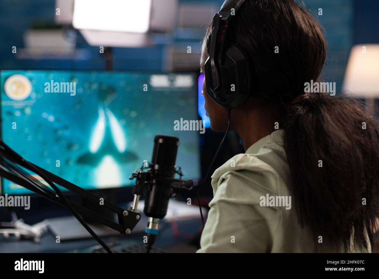 Successful esport gamer wearing headset talking with remote players ...