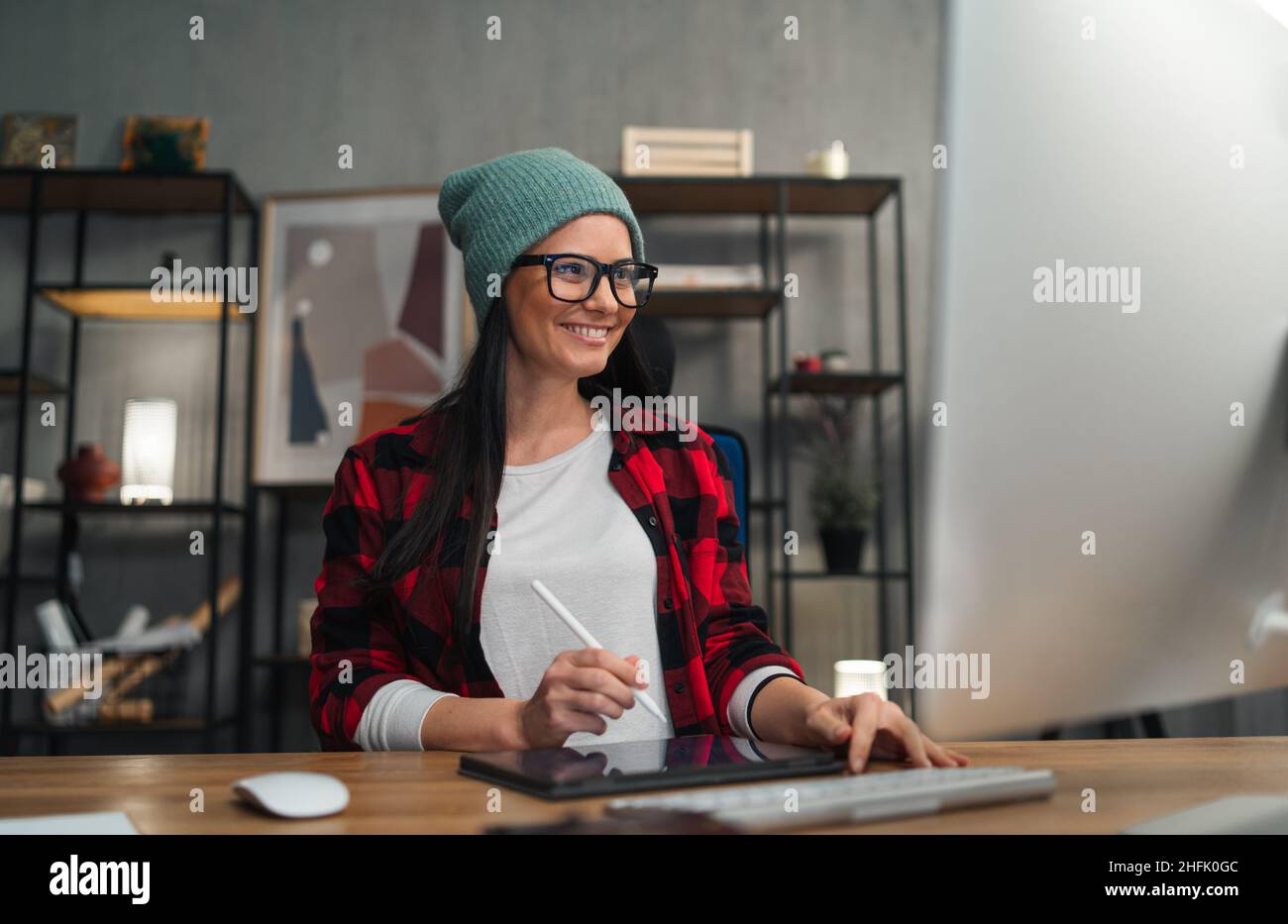 Happy female video editor works indoors in creative office studio Stock ...