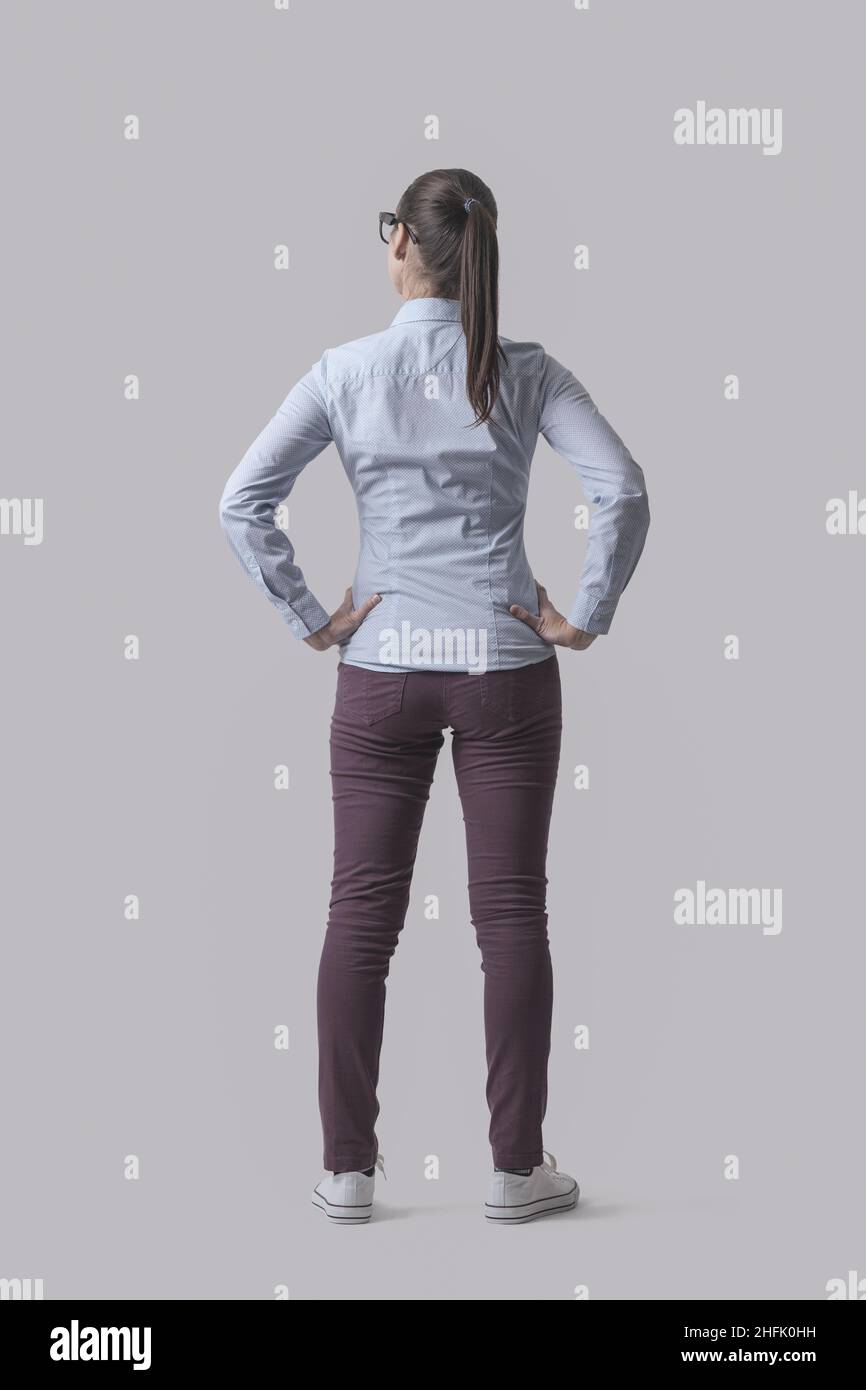 Young woman standing full body back view, isolated on gray background ...