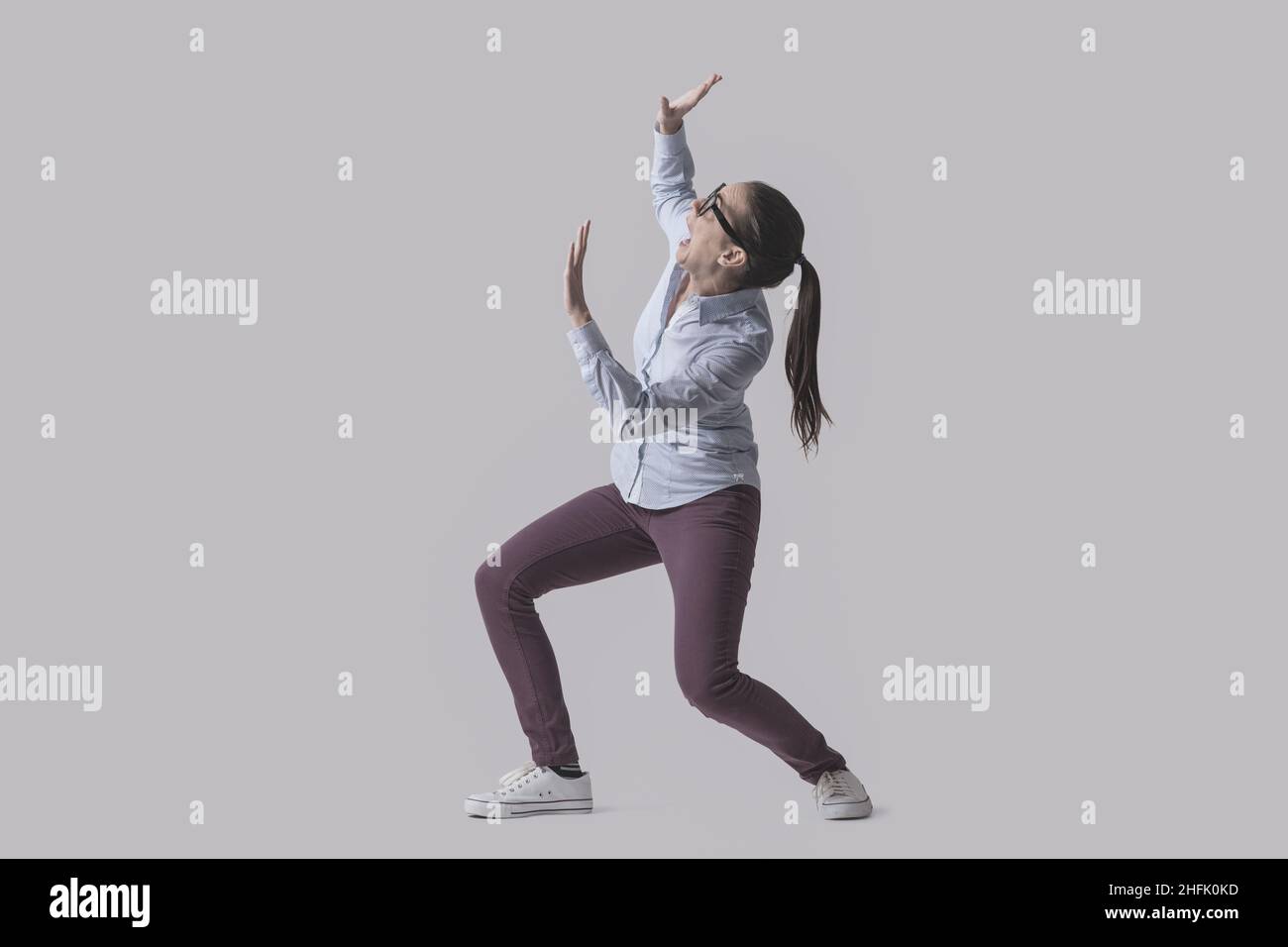 Scared woman protecting herself from a danger, something is falling ...